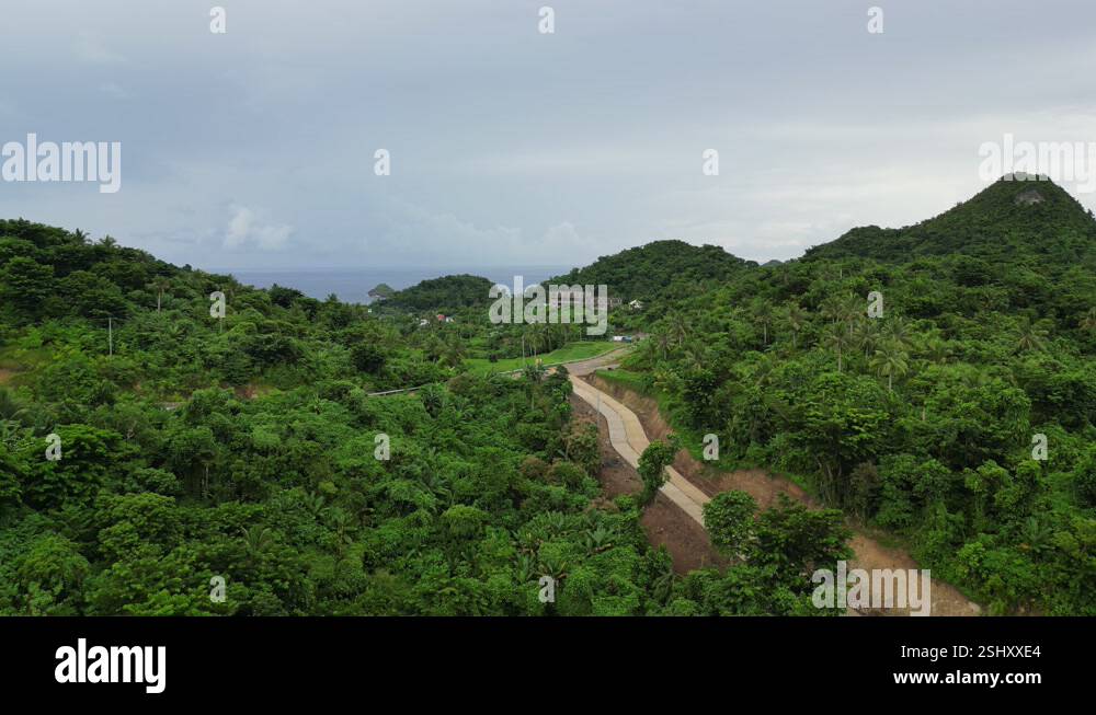 Aerial View of Narrow, hillside Roadways along tropical rainforests in ...
