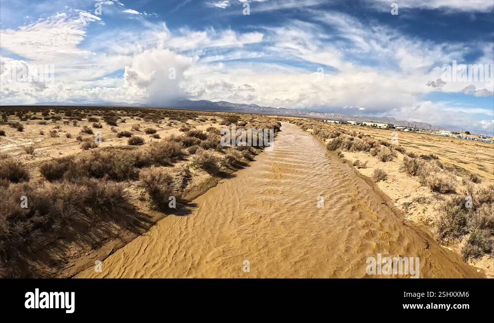 Usually dry riverbed of Cache Creek in the Mojave Desert flowing with ...