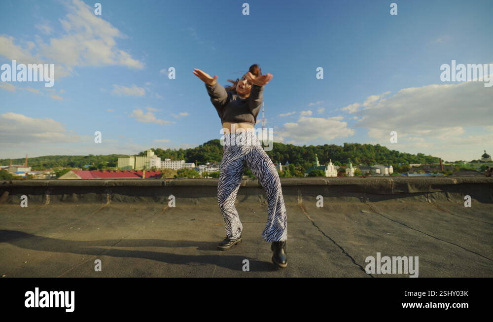 Cool young talented hip-hop girl dancing on the roof floor staring at ...