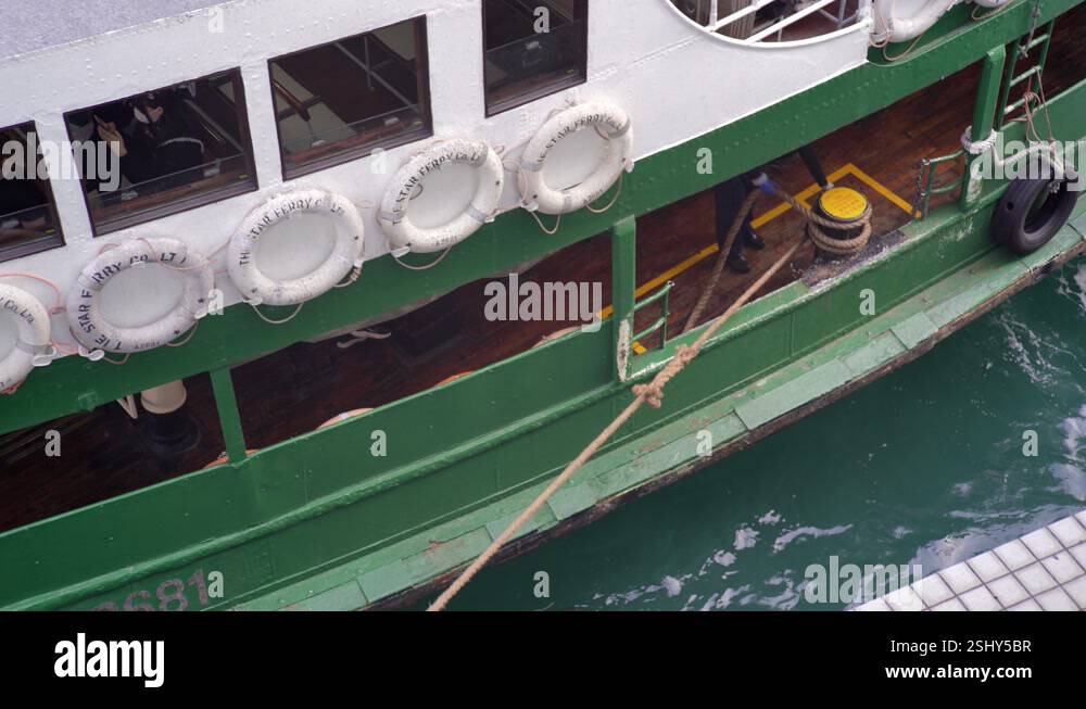 Star Ferry worker fastens mooring line on ship at dock in Hong Kong ...