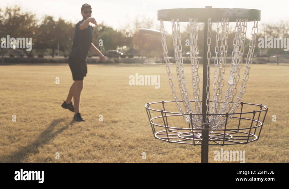 Frisbee Golfer Makes a Putt into the Chains of a Disc Golf Basket Stock ...