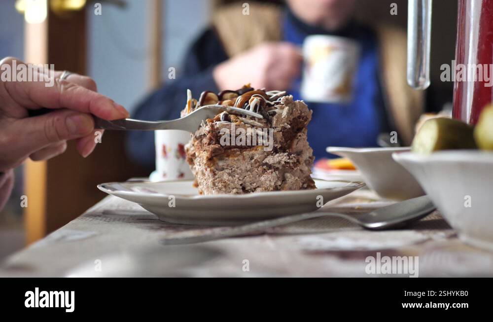 There is a Snickers cake. Bite the cake with a fork. Sweet breakfast ...