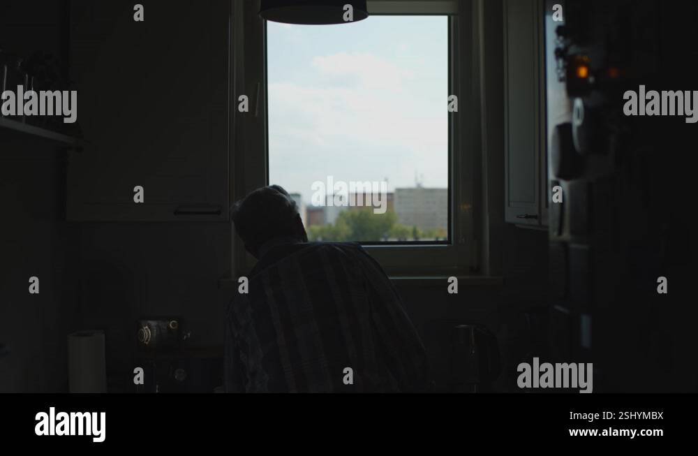Man looking out of the windows to block of flats dark kitchen 4K Stock ...
