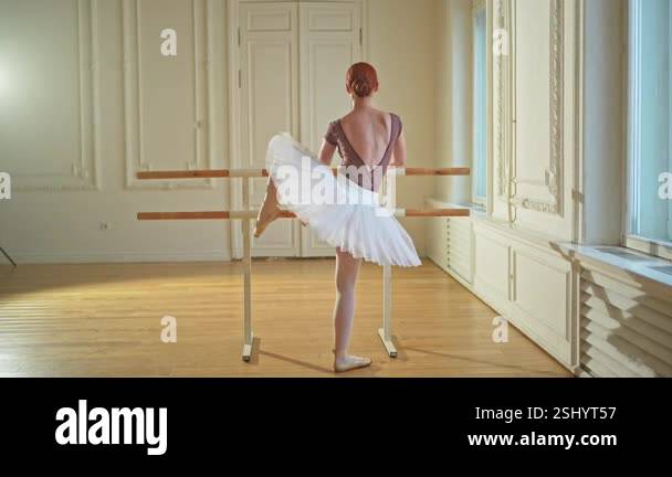 Young ballerina in tutu skirt stretching practicing ballet positions ...