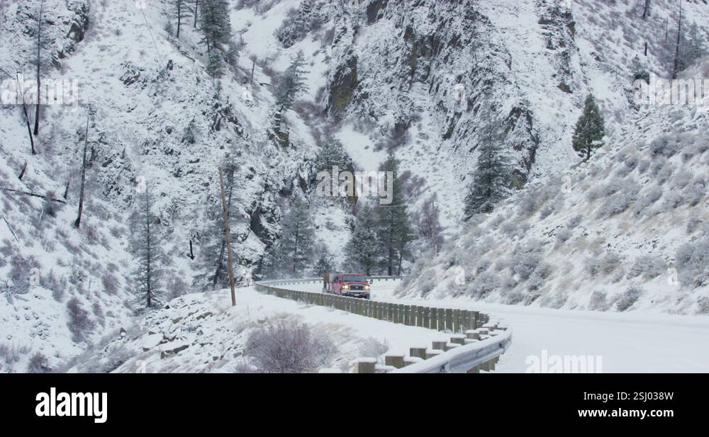 Truck pulling trailer passes by on snow covered winter highway in ...