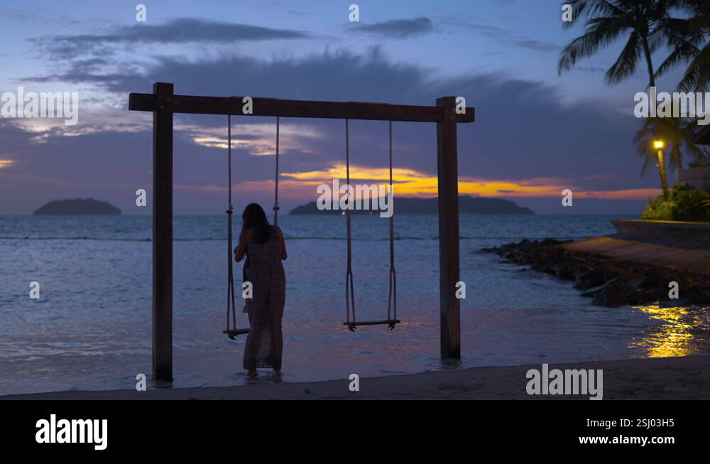 Young Mother Puts the Child on Beach Rope Swing At Majestic Tropical ...