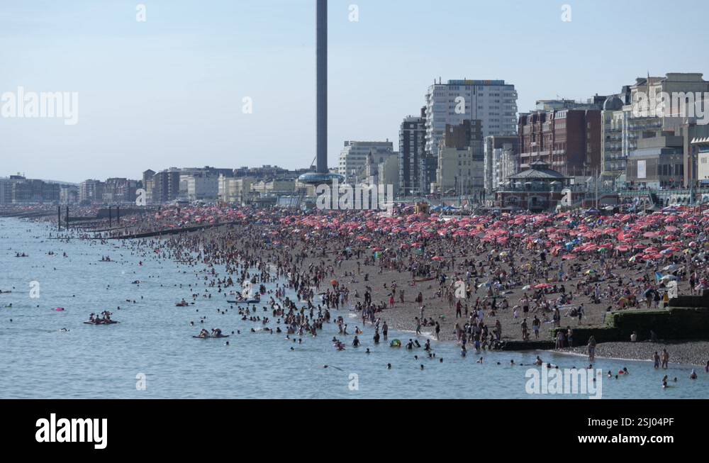 Brighton beach in heatwave crowded with people relaxing in the hot sun ...
