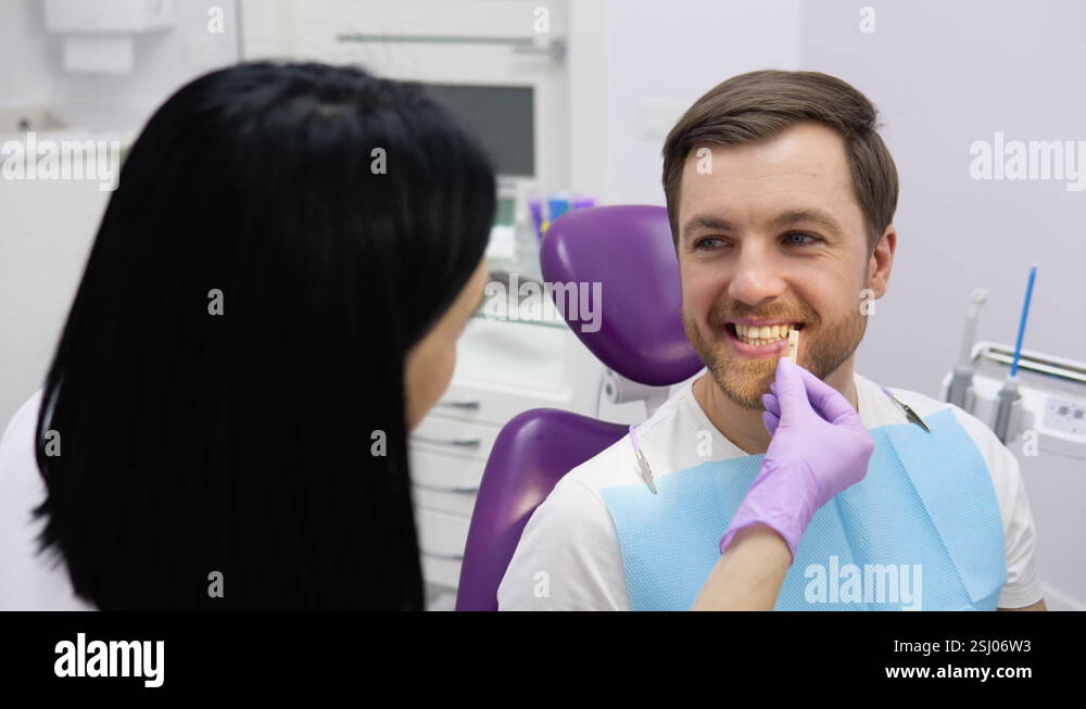 Dentist selecting tooth color from special scale. Selection of the ...