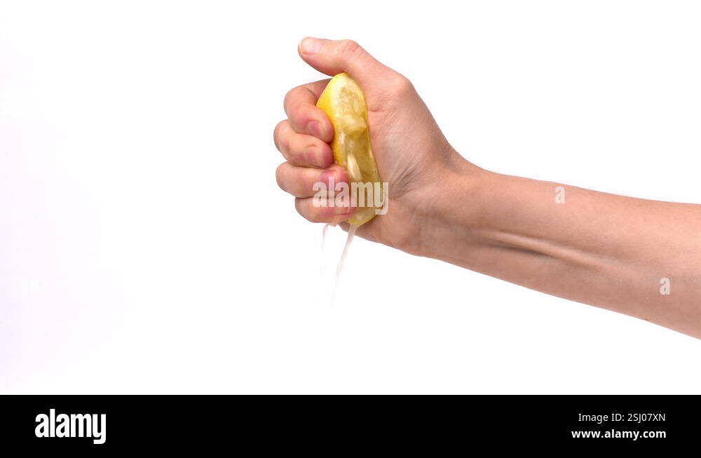 Male hand compressing fresh organic lemon half squeeze juice drop ...