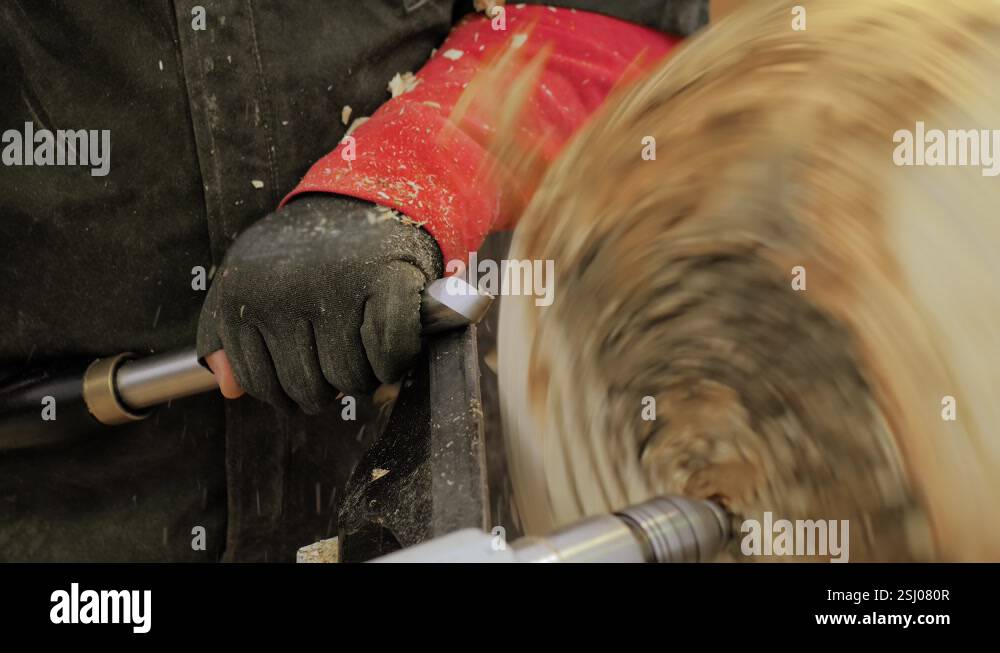 Close up: carpenter using chisel for shaping piece of wood on lathe ...