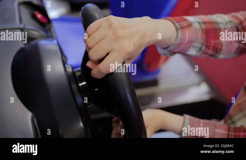 Woman using gaming steering wheel joystick at retro arcade hall: close ...