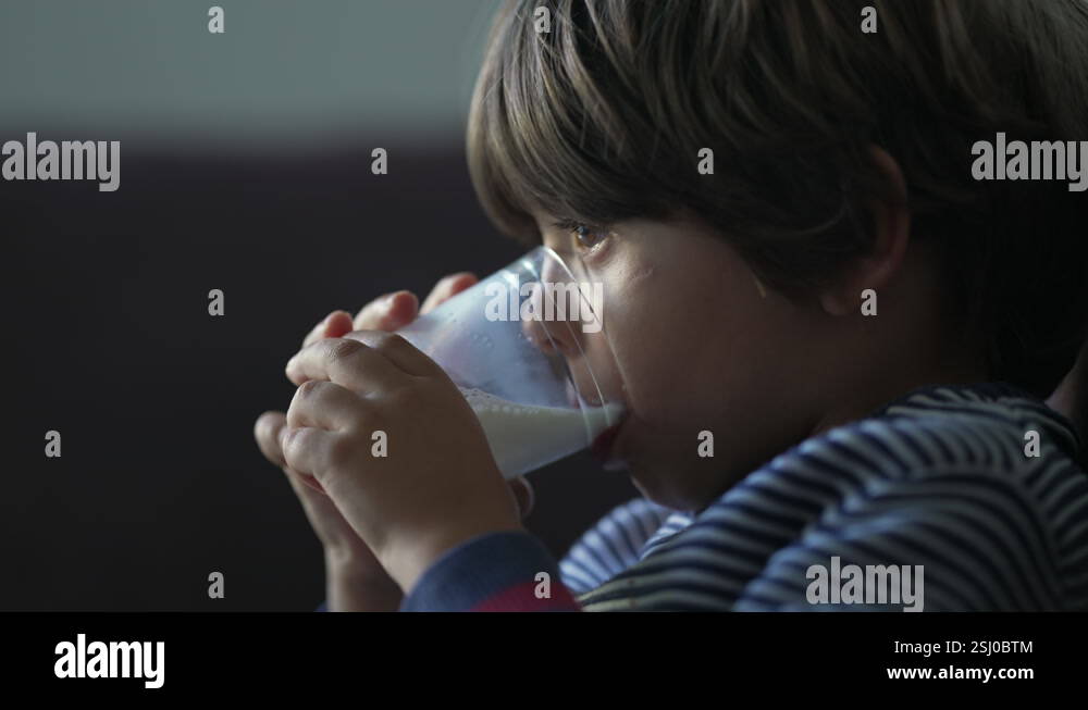 Child drinking glass of milk. One little boy drinks nutritious drink ...