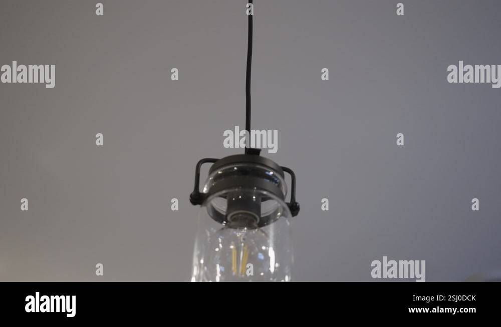 Tilting down from the base of a fancy light fixture with an Edison bulb ...