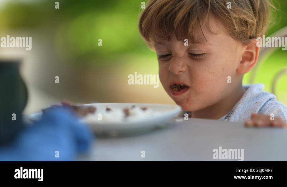 Feeding child food. Funny scene of mischievous little boy taking a bite ...