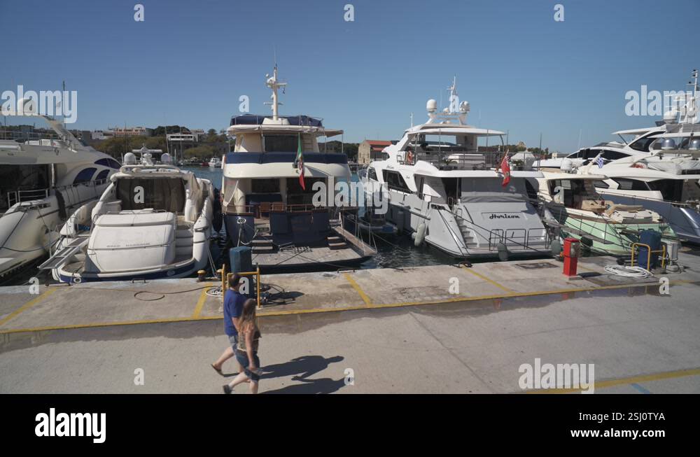 Luxury boats in Mandraki Harbour and old town in background, Rhodes ...