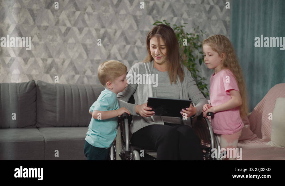Mother smiles showing videos to curious children on tablet Stock Video Footage - Alamy
