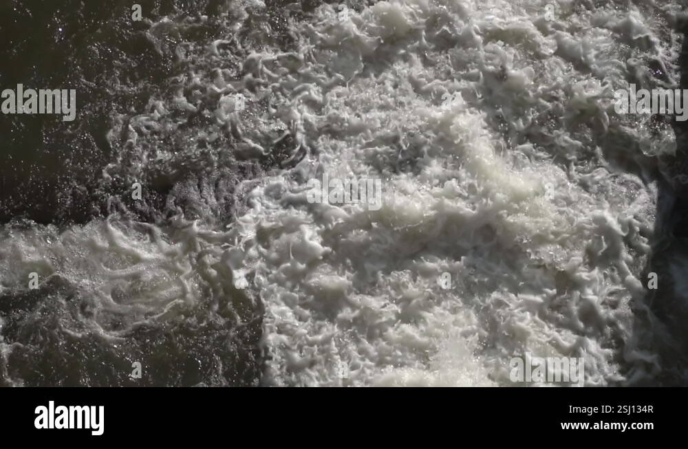 Aerial view of a cascade of water that overflows from the dam. Slow ...