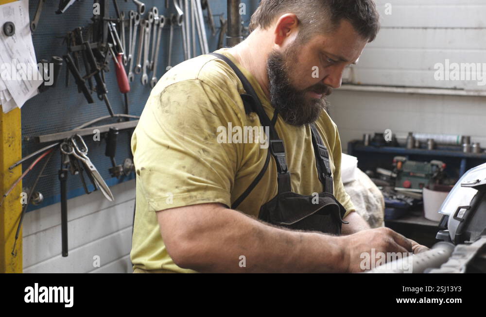 Profile of auto mechanic in uniform works with car at garage. Repairman ...