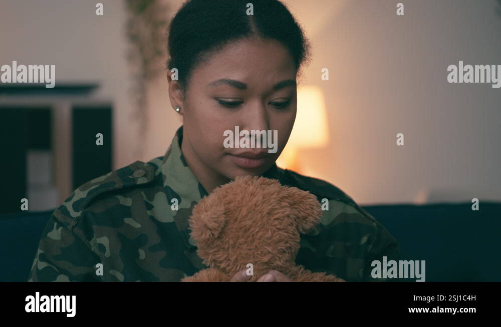 Sad female soldier crying and hugging teddy bear toy, missing family ...