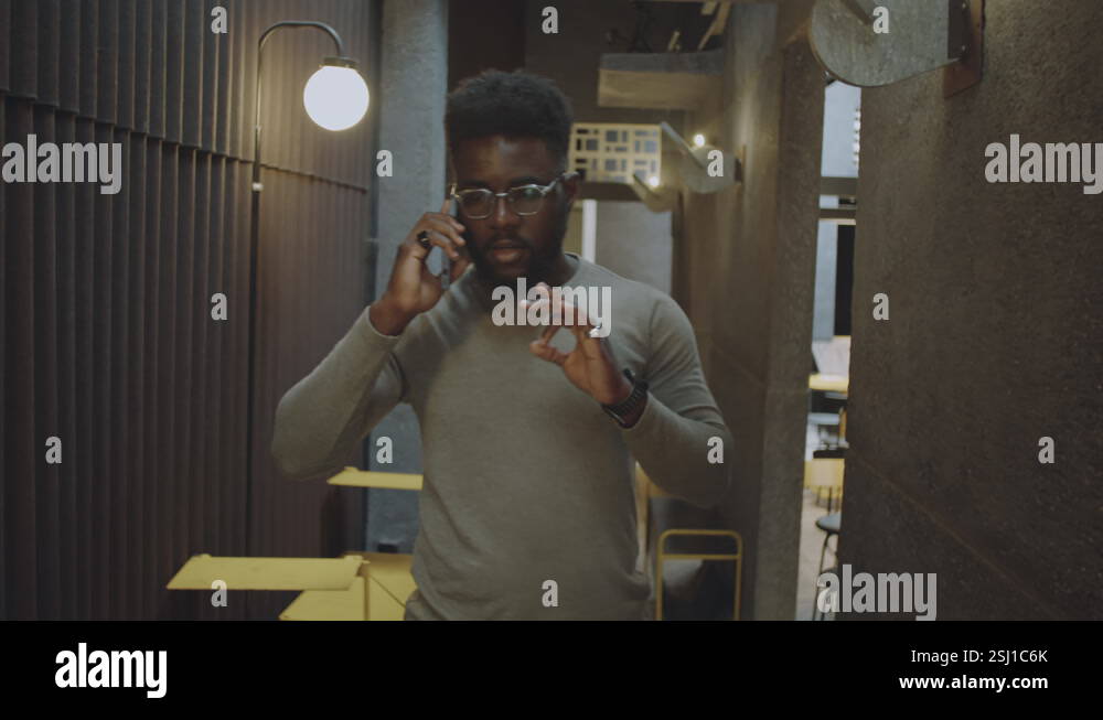 Black Man Walking through Cafe and Speaking on Phone Stock Video ...