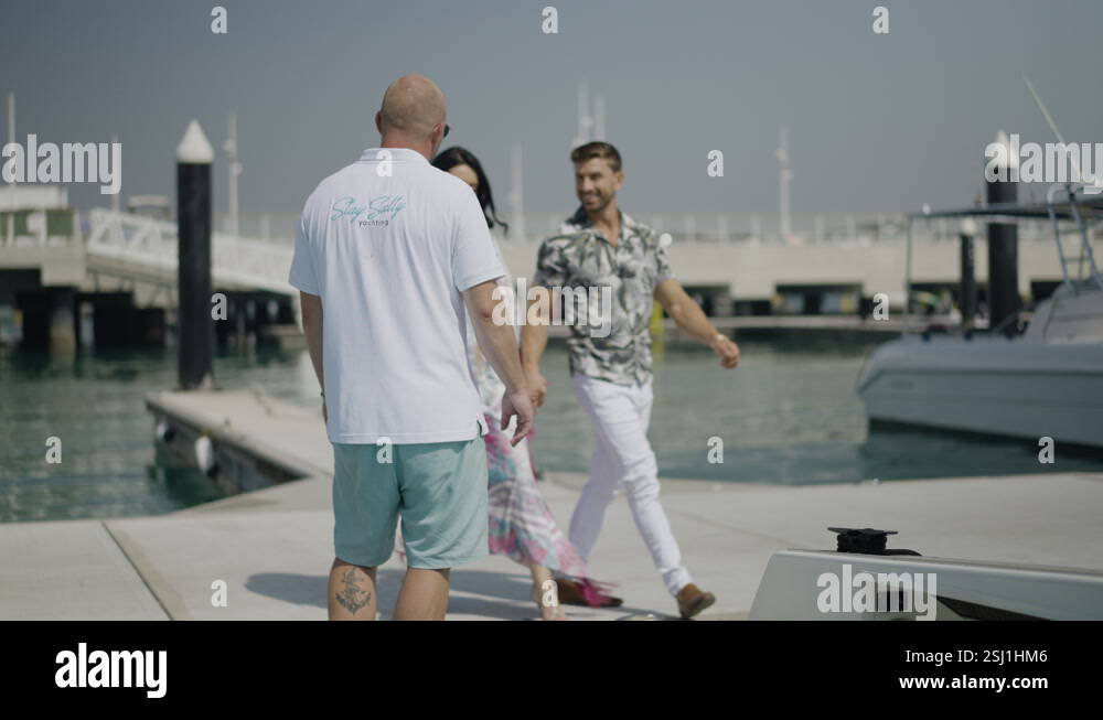 Slow motion tracking shot of a couple meeting their captain and walking ...