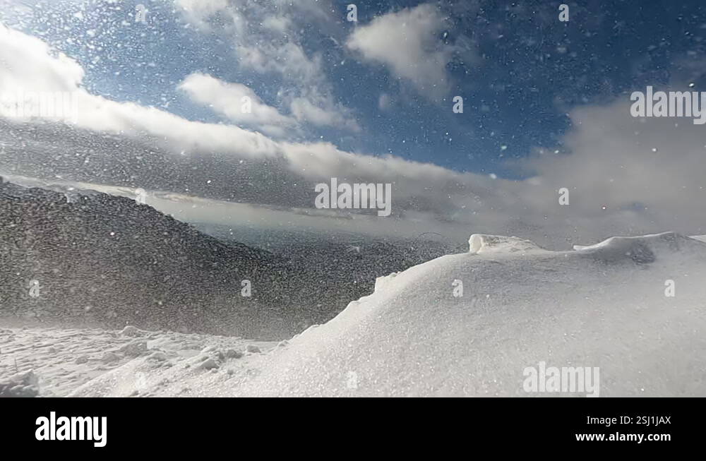 Snow drifting during a storm and strong wind in the mountains on a cold ...