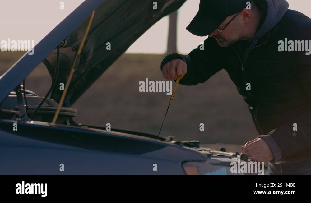 Sad disappointed man on broken car accident. Vehicle check engine oil ...