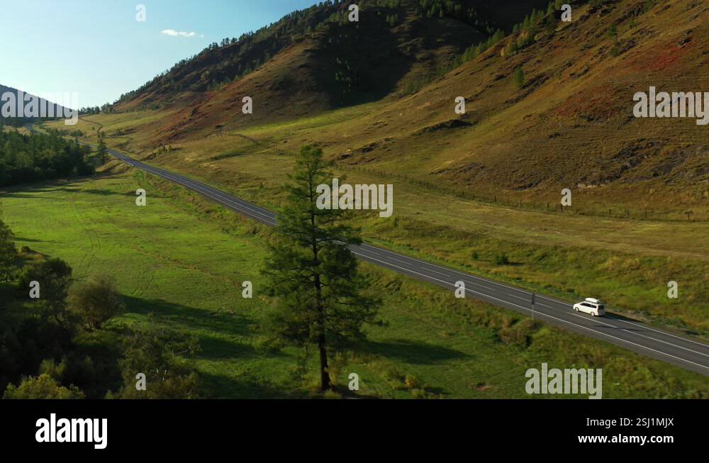 White SUV van riding on evening asphalt road summer mountain scenery ...