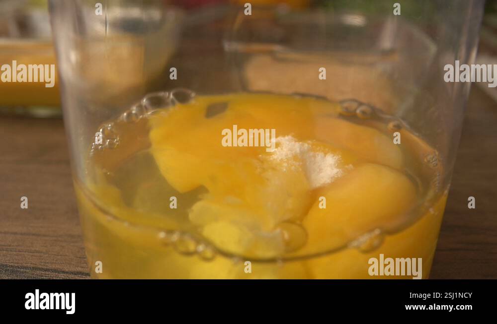 Salt is poured into raw eggs in a glass beaker Stock Video Footage - Alamy