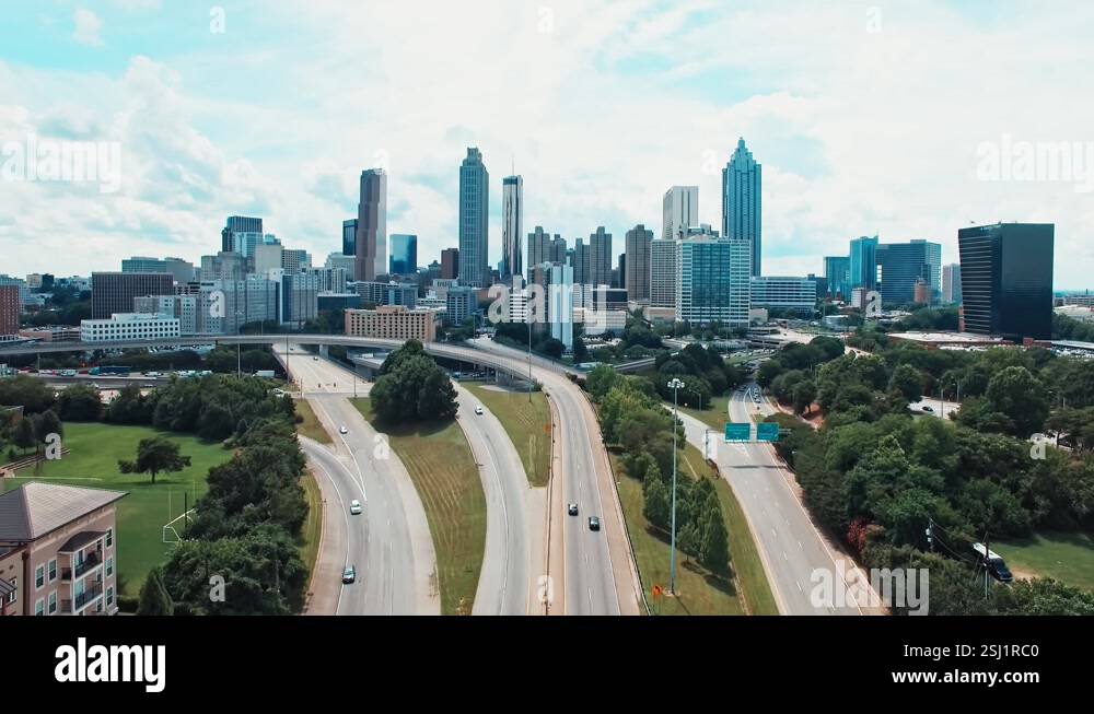 Freeway entrance to Atlanta city skyline, aerial forward drone on sunny ...