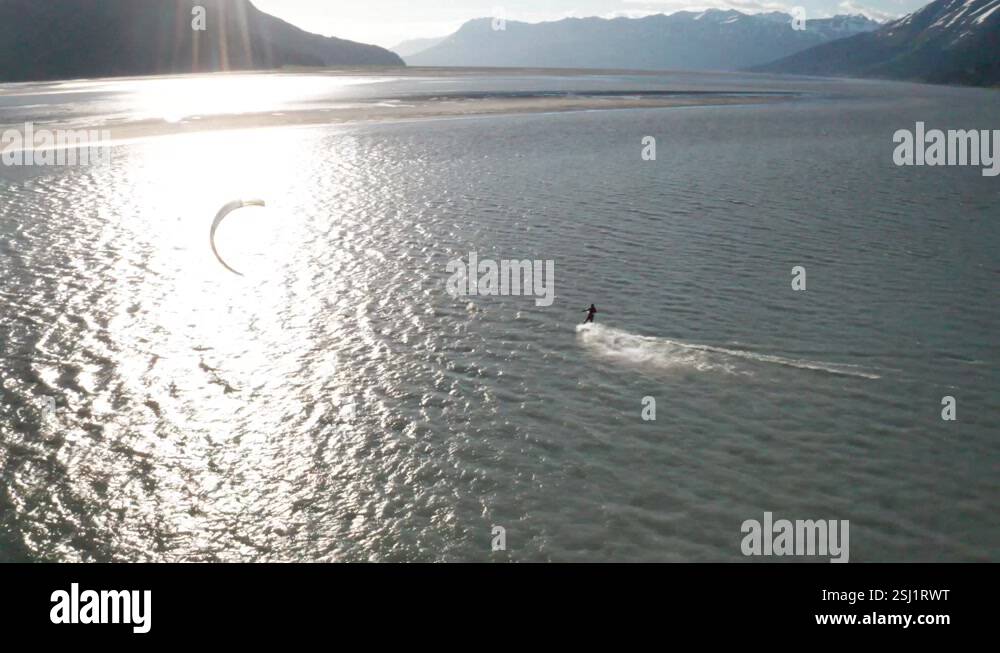 Drone footage of a water skier para-skiing with a parachute on a windy ...