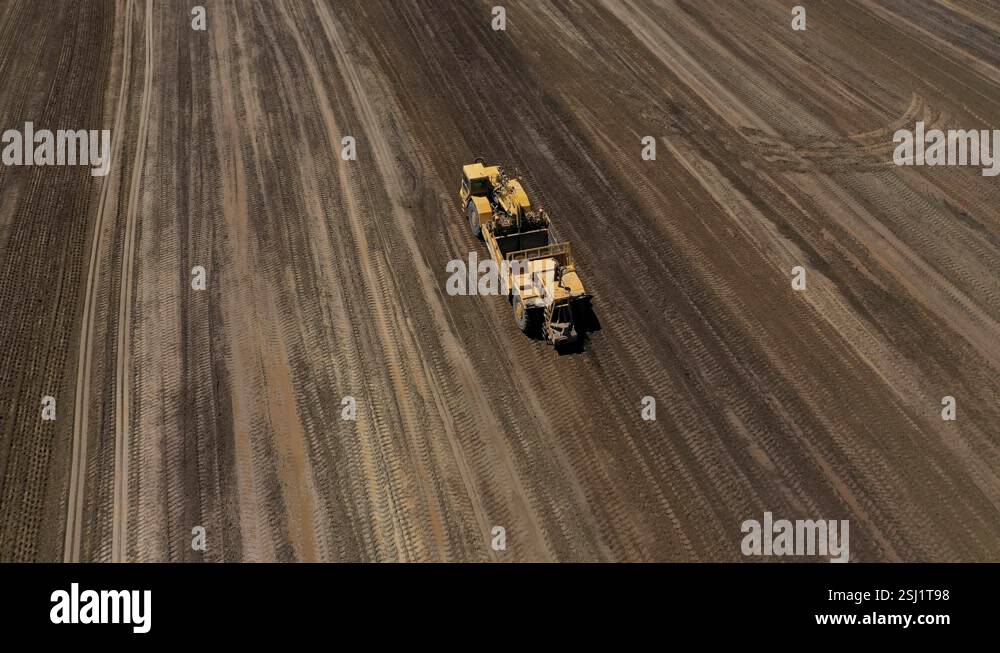 Motor scraper on job site grading the land for construction. Overhead ...