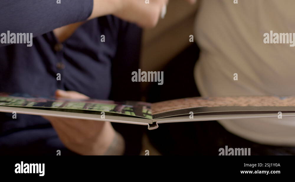 Close-up moving hand over photo book. Using hands gestures while speak ...