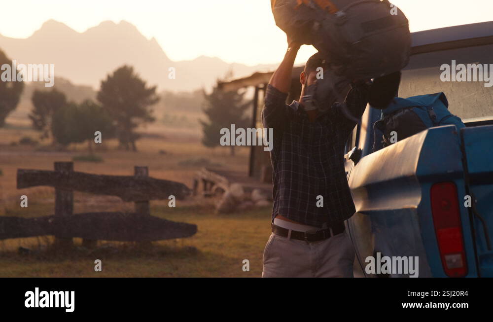 Portrait Of Man Unloading Backpacks From Pick Up Truck On Road Trip To ...