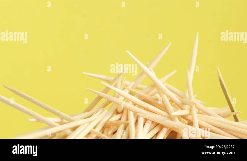 A group of rotating wooden toothpicks on a yellow background Stock Video Footage - Alamy