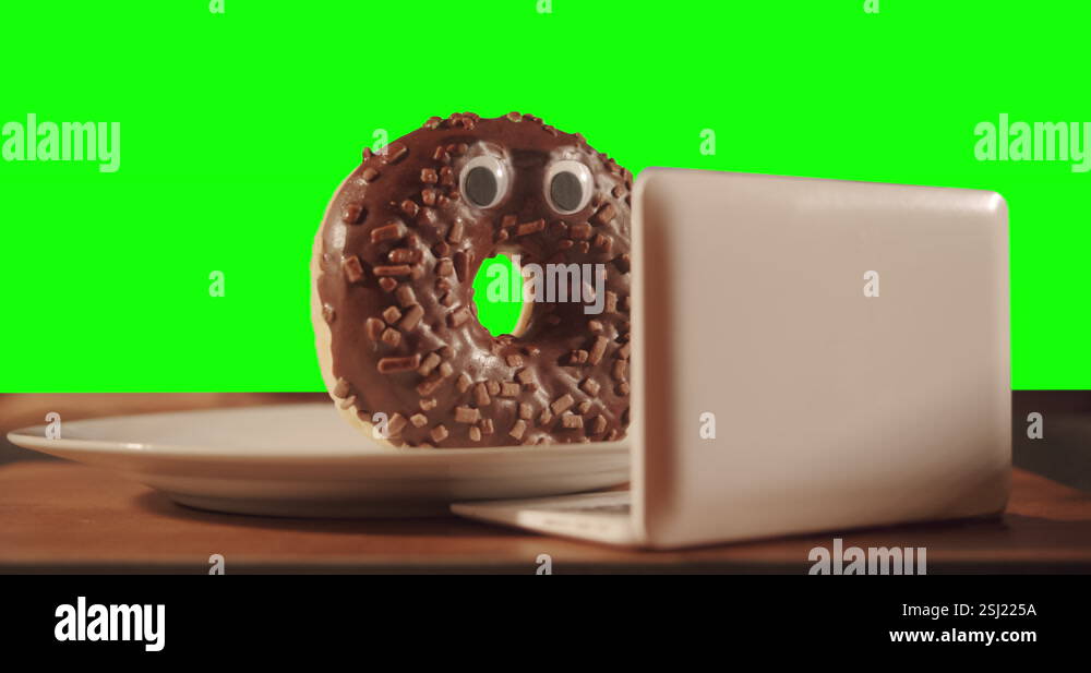 Donut using laptop. Watching content about the harmful of sugar. Green ...