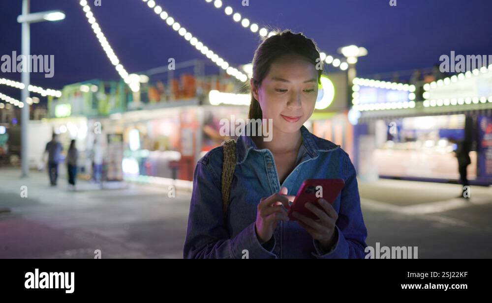 Woman use mobile phone in city at night Stock Video Footage - Alamy