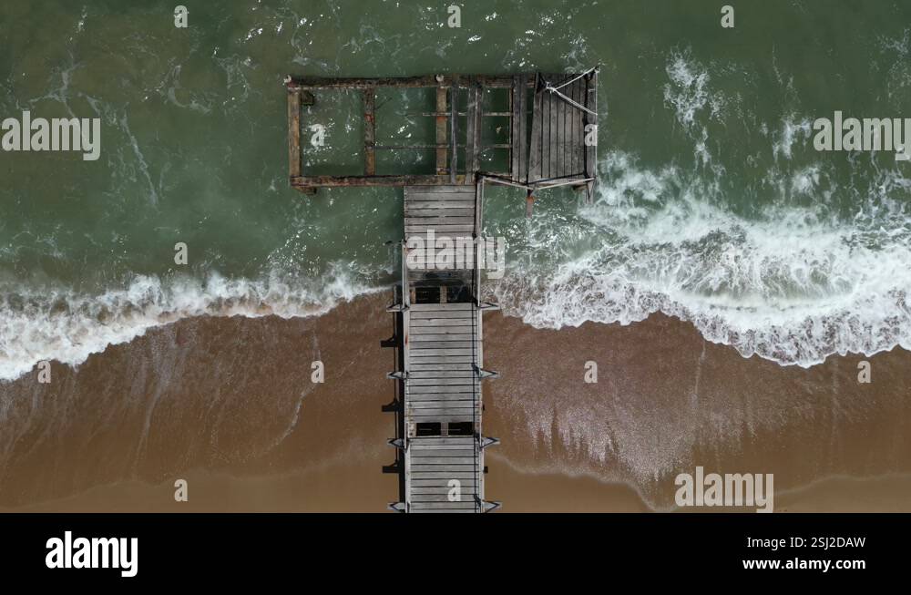 Aerial static footage above a pontoon in ruins at the beach in Nha ...