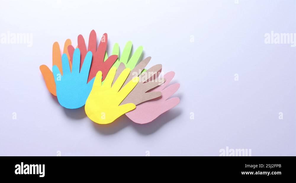 Close up of hands together made of colourful paper on white background ...