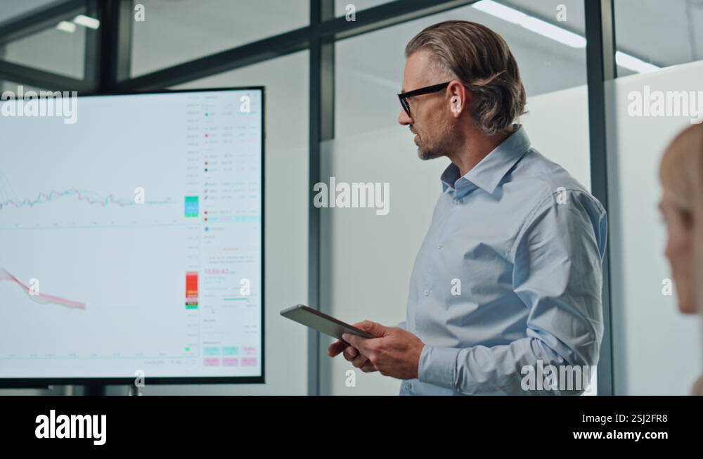 Confident man pointing screen in meeting room. Specialist presenting ...