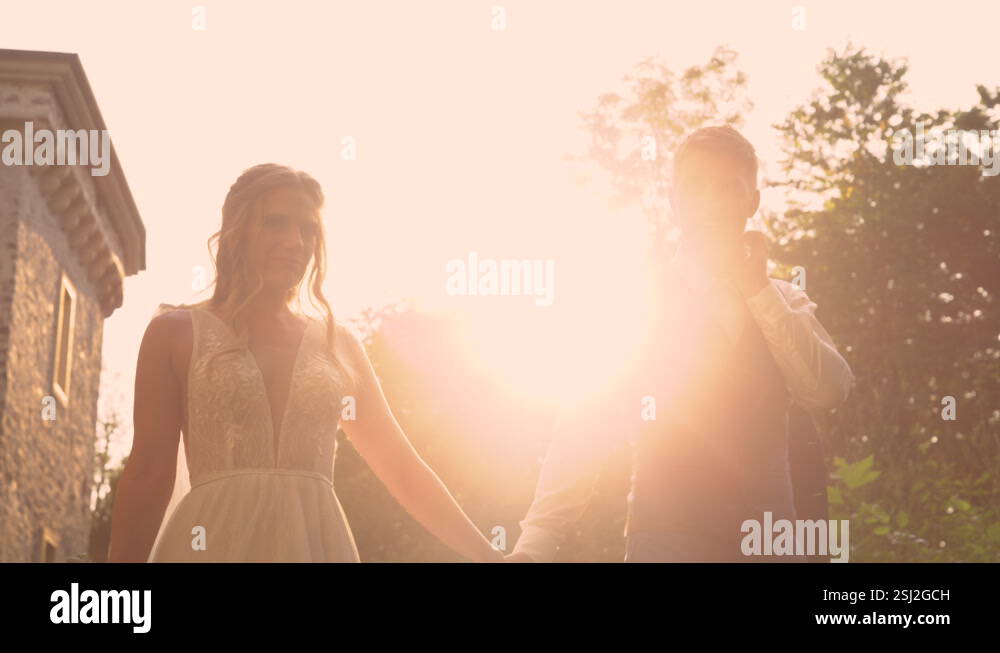 LENS FLARE, PORTRAIT Newly married bride and groom illuminated with ...