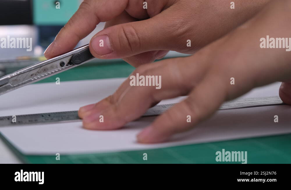 Close-up hands of female cutting paper using utility knife cutter Stock ...