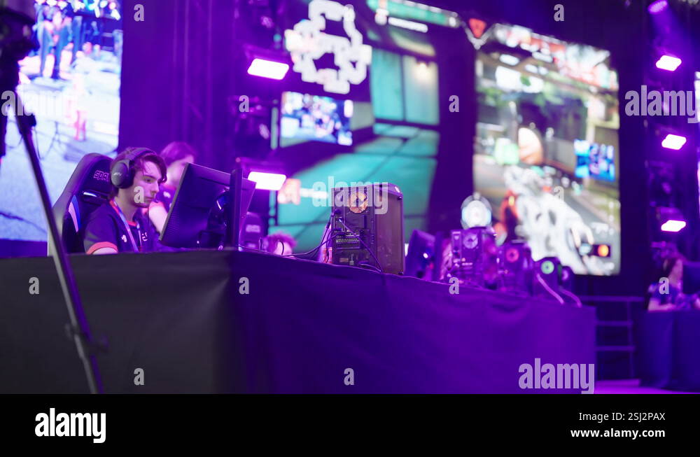 Gamers playing first person shooter game on stage on live tournament 4K ...