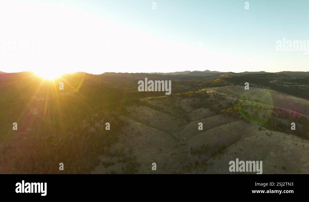 Rising aerial view of the sun rising over South Dakota's Custer State ...
