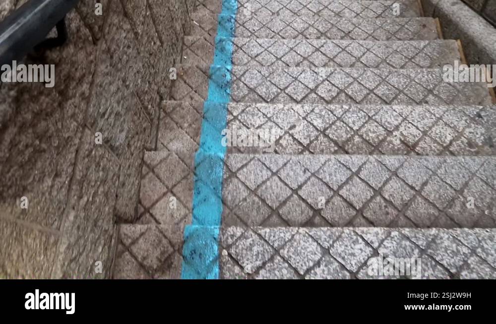 POV descending concrete stairs with grill pattern and blue line at ...