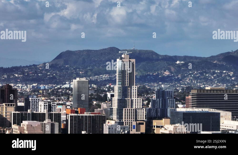 Zoomed shot of high rise office towers in city and Hollywood Sign in ...