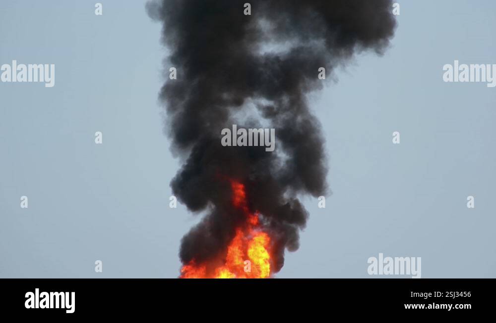 Petroleum refinery gas flare blazing fire pouring thick black smoke ...