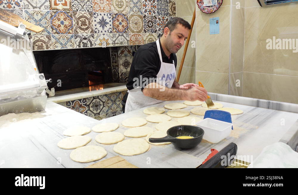Man prepares fresh bread in wood oven, bakery in Northern Nicosia ...