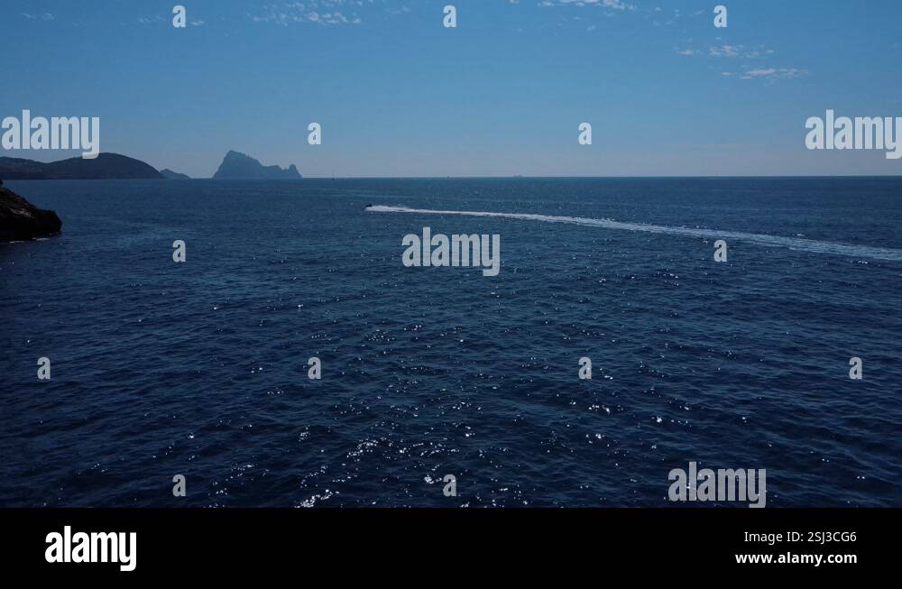 A fast speedboat cruising on the blue sea of a tropical shore. shimmers ...