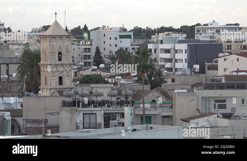 Contrast between historic church tower and modern buildings in Larnaca ...